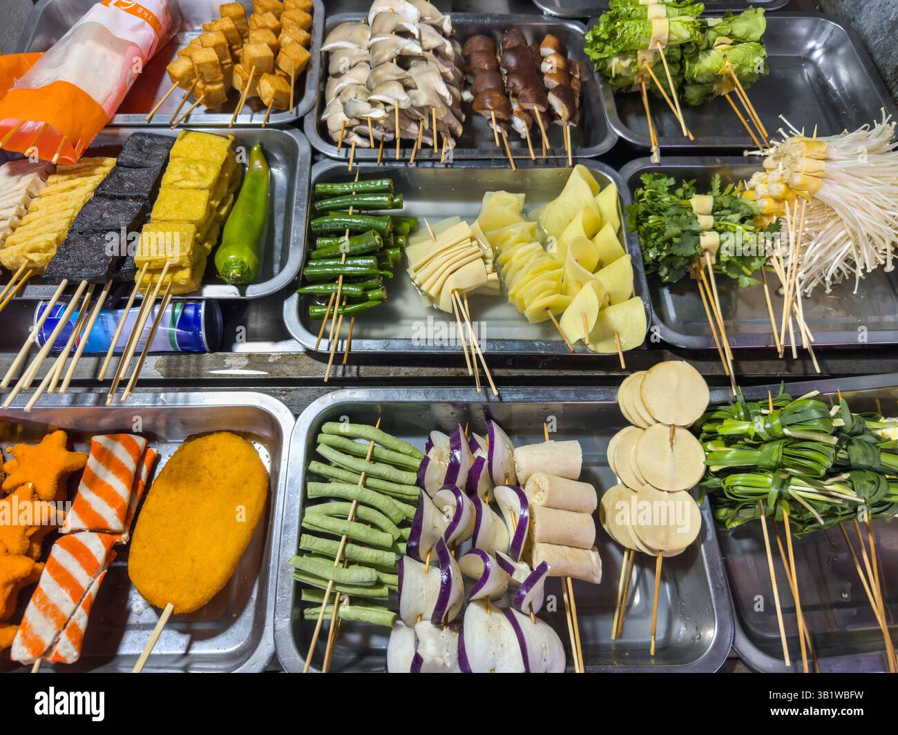 Night market street food stall in China. Raw vegetable skewers variety ...