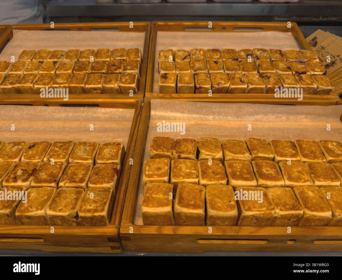 Traditional chinese pastry in wooden trays at a bakery display ...