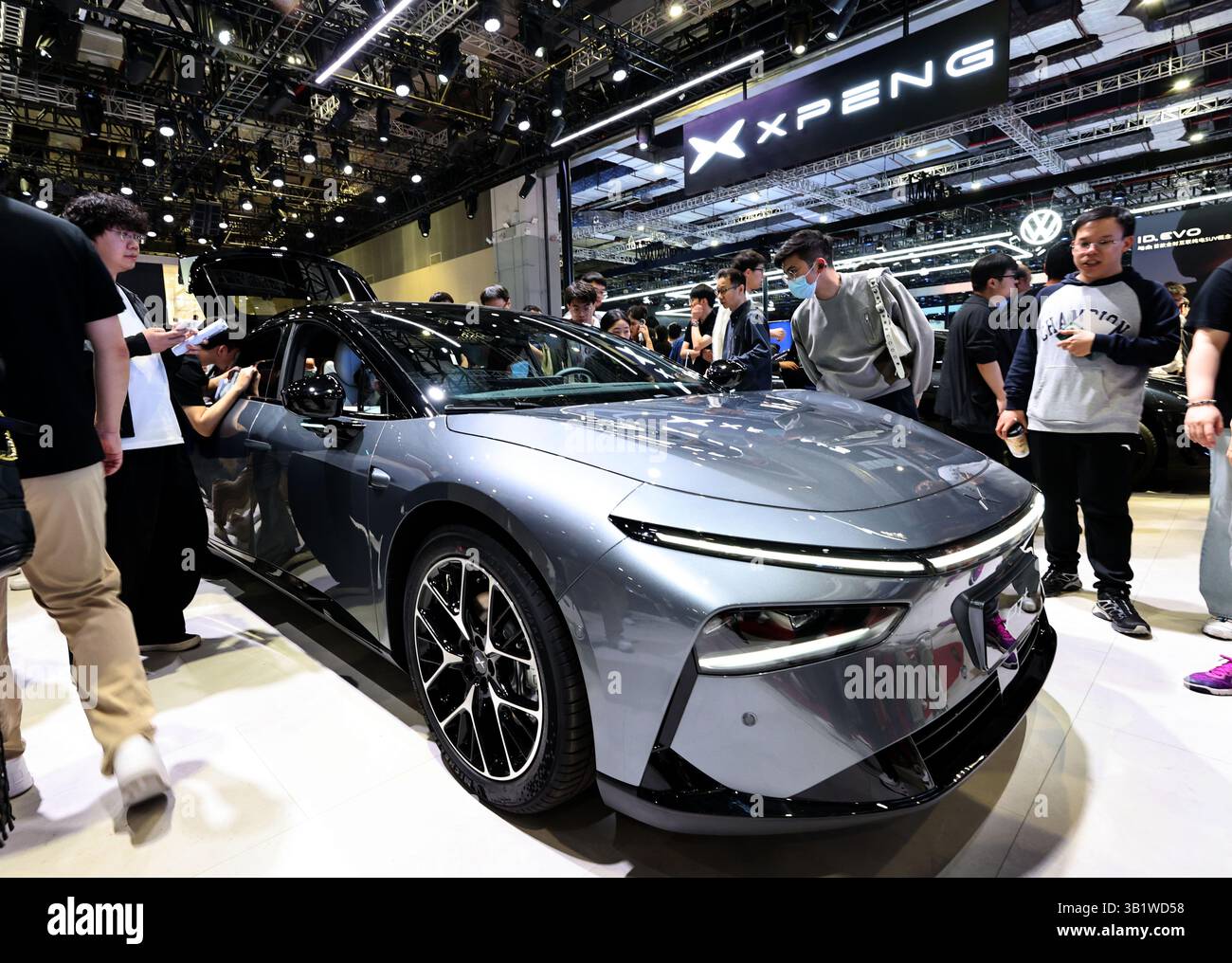 Shanghai. 26th Apr, 2025. Visitors look at an Xpeng P7 on display at ...