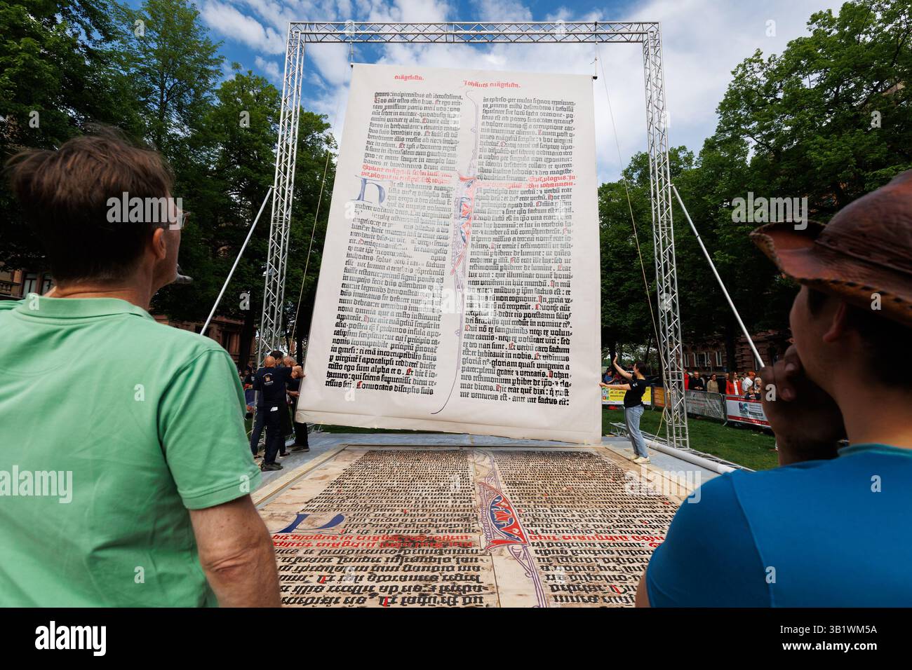 Mainz, Germany. 26th Apr, 2025. The finished XXXL Bible page is hung up ...