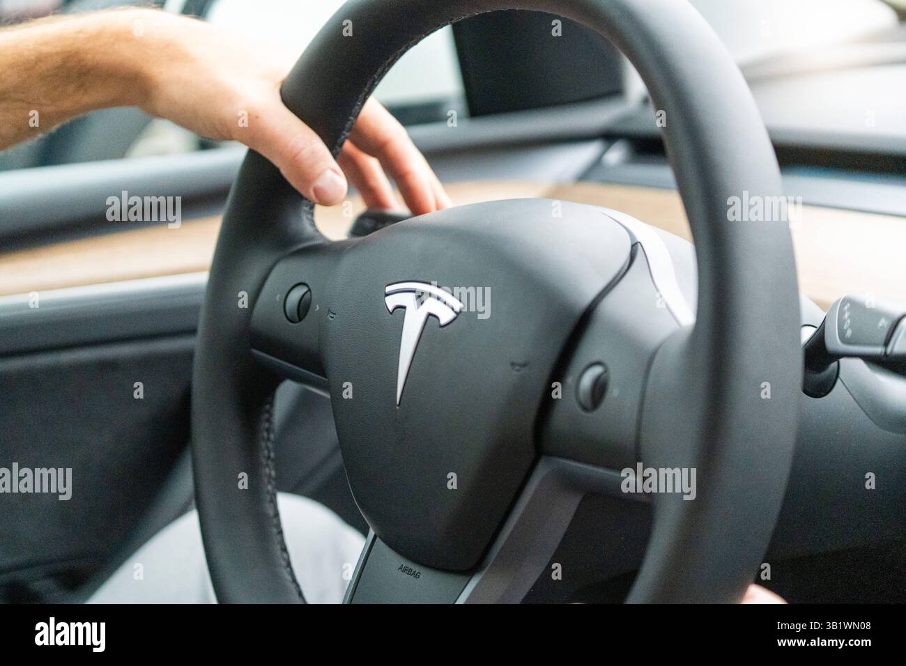 Bavaria, Germany - April 26, 2025: A hand reaches into the steering ...