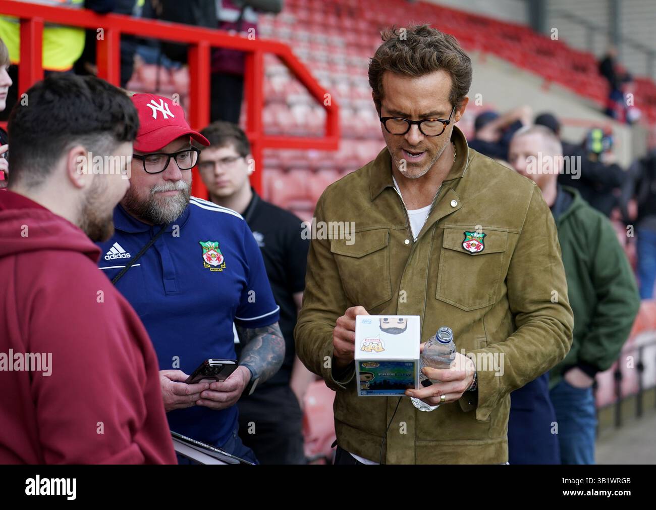 Wrexham co-owner Ryan Reynolds (right) signs an autograph for a fan ...
