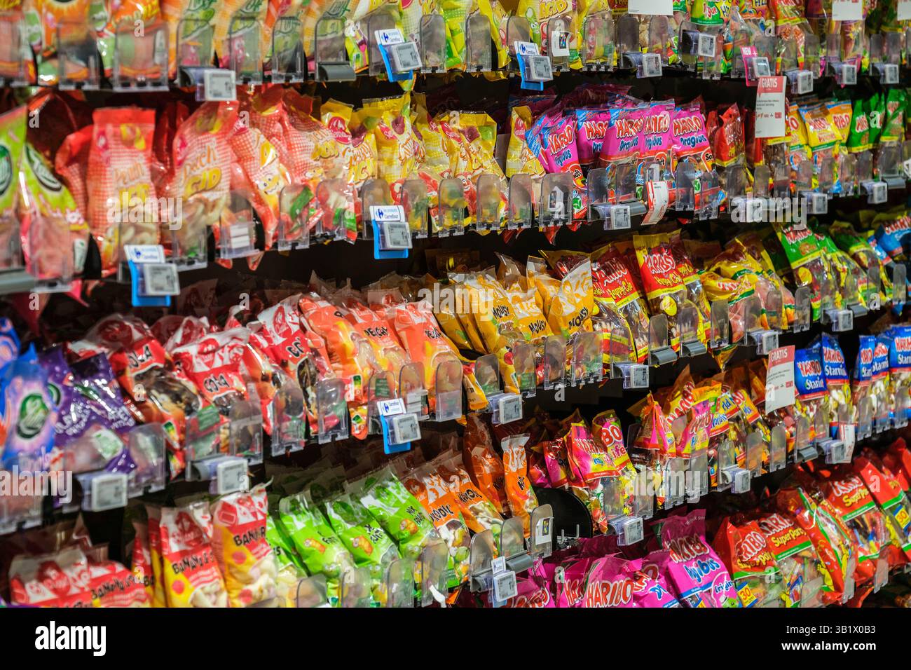 paquets de bonbons colorés dans les rayons d'une grande surface ...