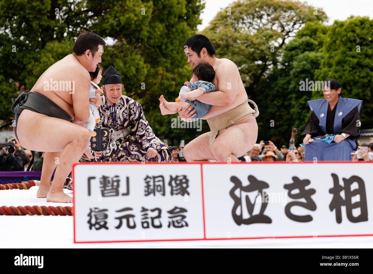 Tokyo, Japan. 26th Apr, 2025. Sumo wrestlers gently coax babies to cry ...