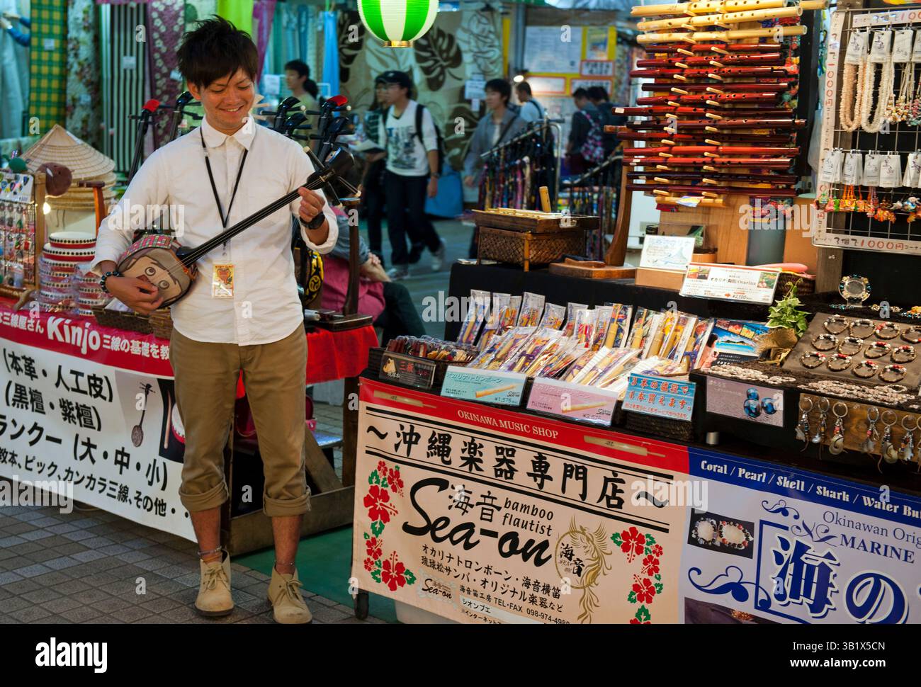 Man playing a traditional Okinawan snakeskin 3-string lute called a ...