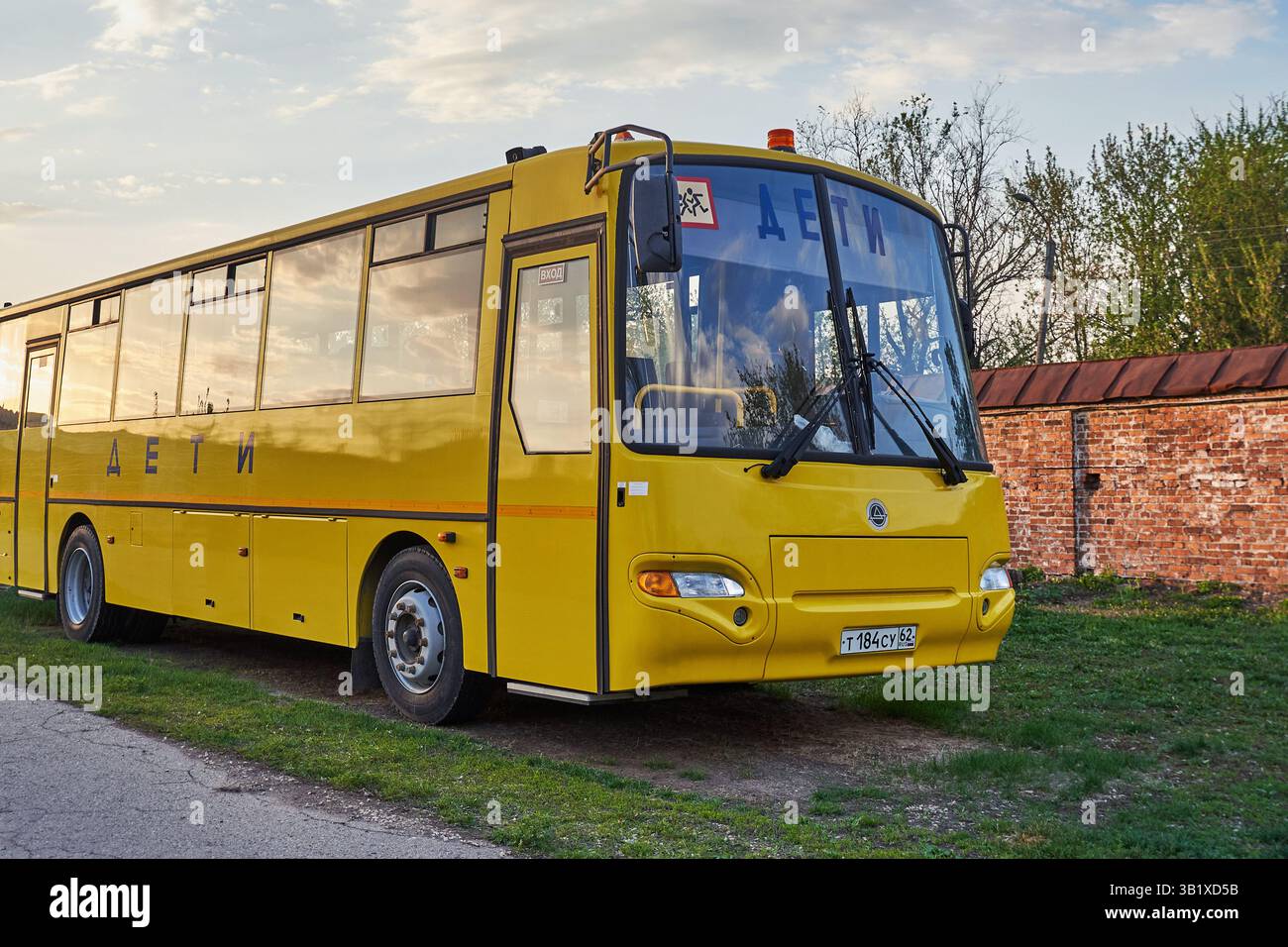 A yellow bus to transport children. Inscription on the bus in Russian ...