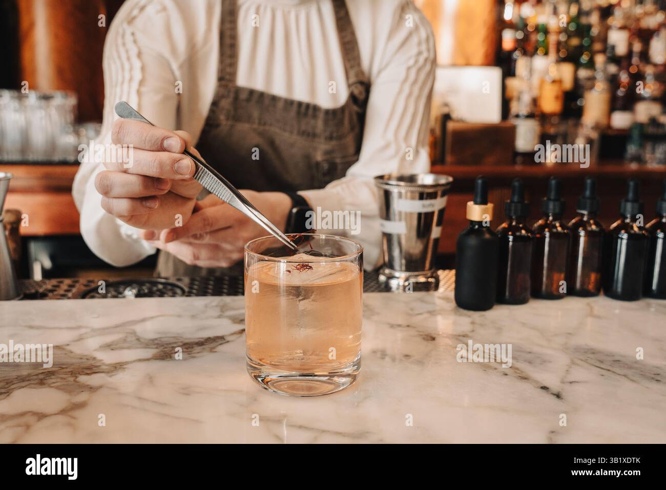 Bartender Using Tweezers for Cocktail Garnish Stock Photo - Alamy