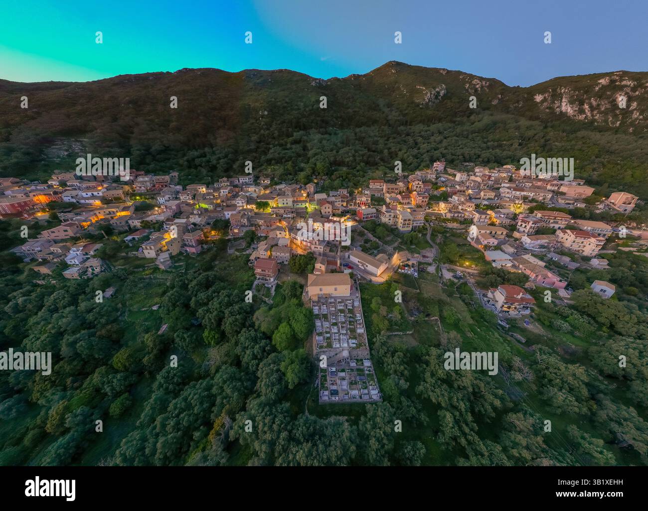 Aerial view of a hillside village with glowing lights nestled among ...