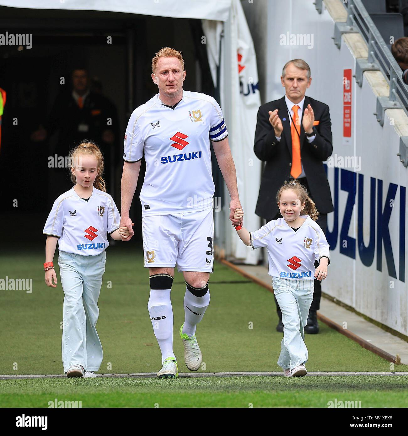 Milton Keynes Dons Defender Dean Lewington (3) walks onto the pitch with his two daughters for ...