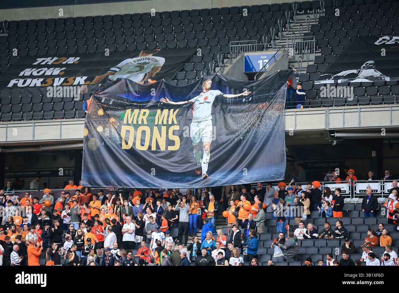 Milton Keynes Dons Fans display a banner of Milton Keynes Dons Defender ...