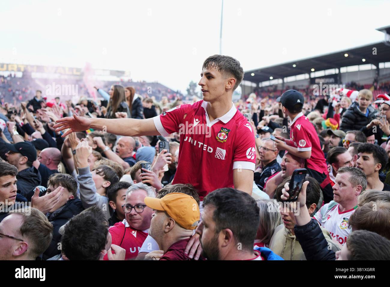 Wrexham's Max Cleworth celebrates with teammates and fans as they win ...