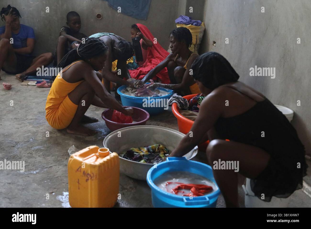 Women wash their clothes at a shelter for families displaced by gang ...
