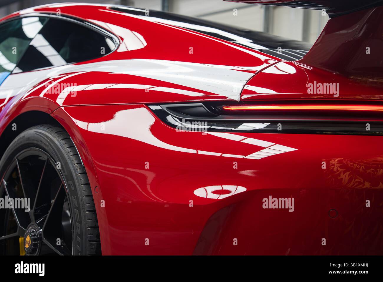 Close up view of the rear of a red 2025 Porsche 911 GT3 922 indoors ...