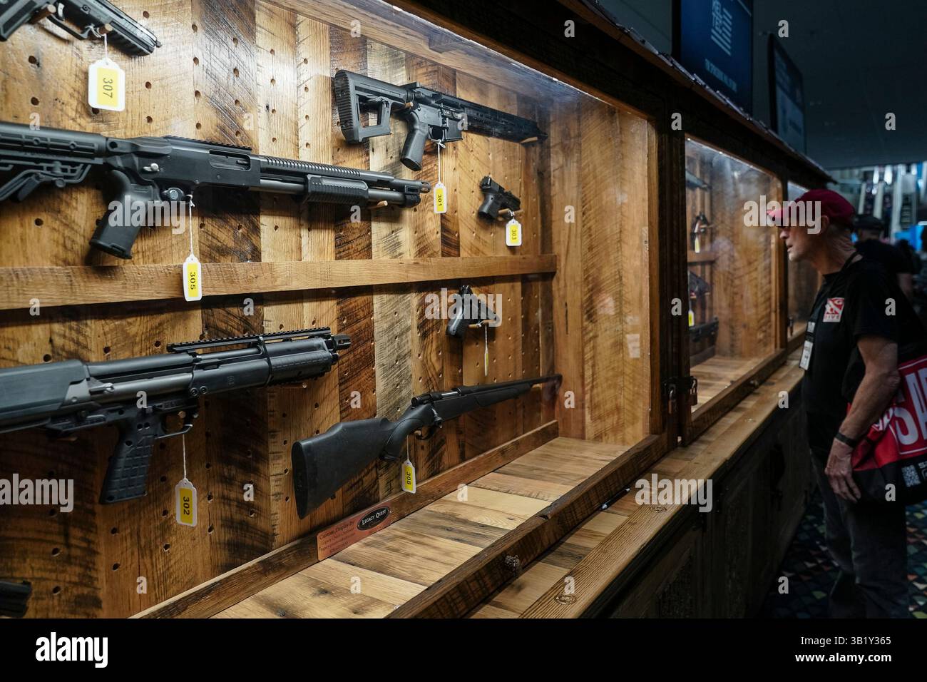 Atlanta, USA. 26th Apr, 2025. A man looks at a gun at the 'Wall of Guns ...