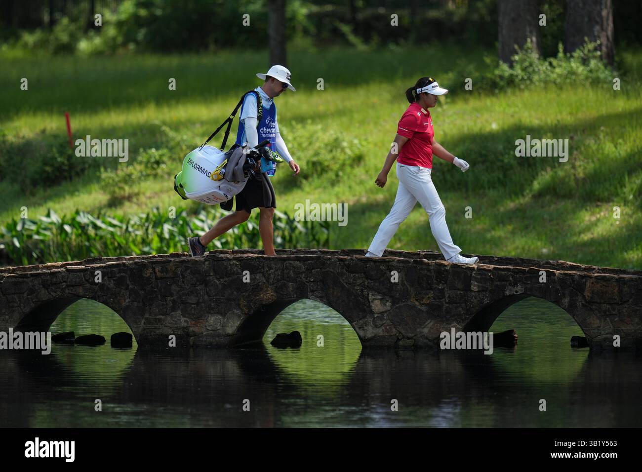 Haeji Kang, of South Korea, and caddie walks across a bridge on the ...