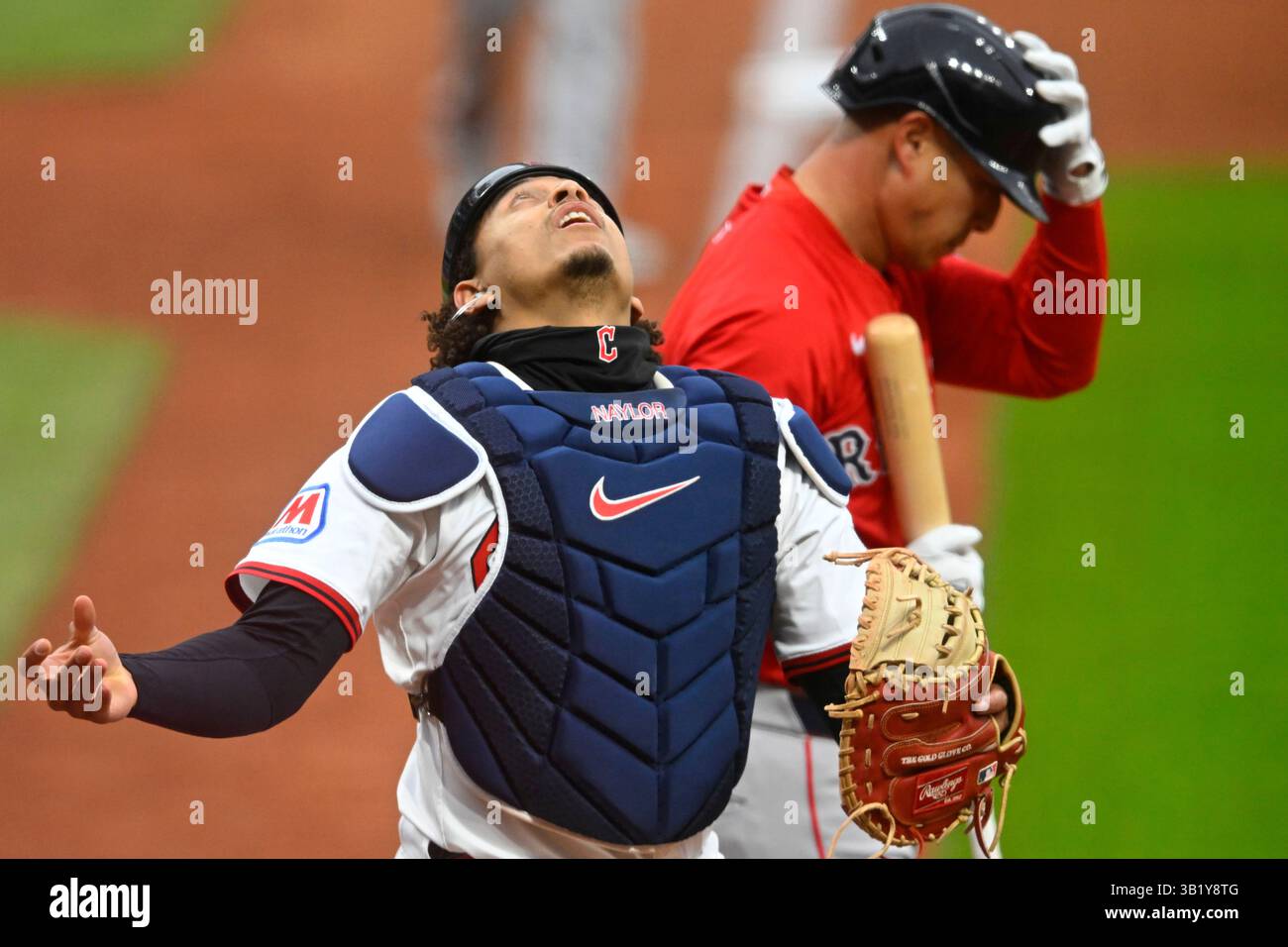 Cleveland Guardians catcher Bo Naylor, left, looks for a foul ball ...