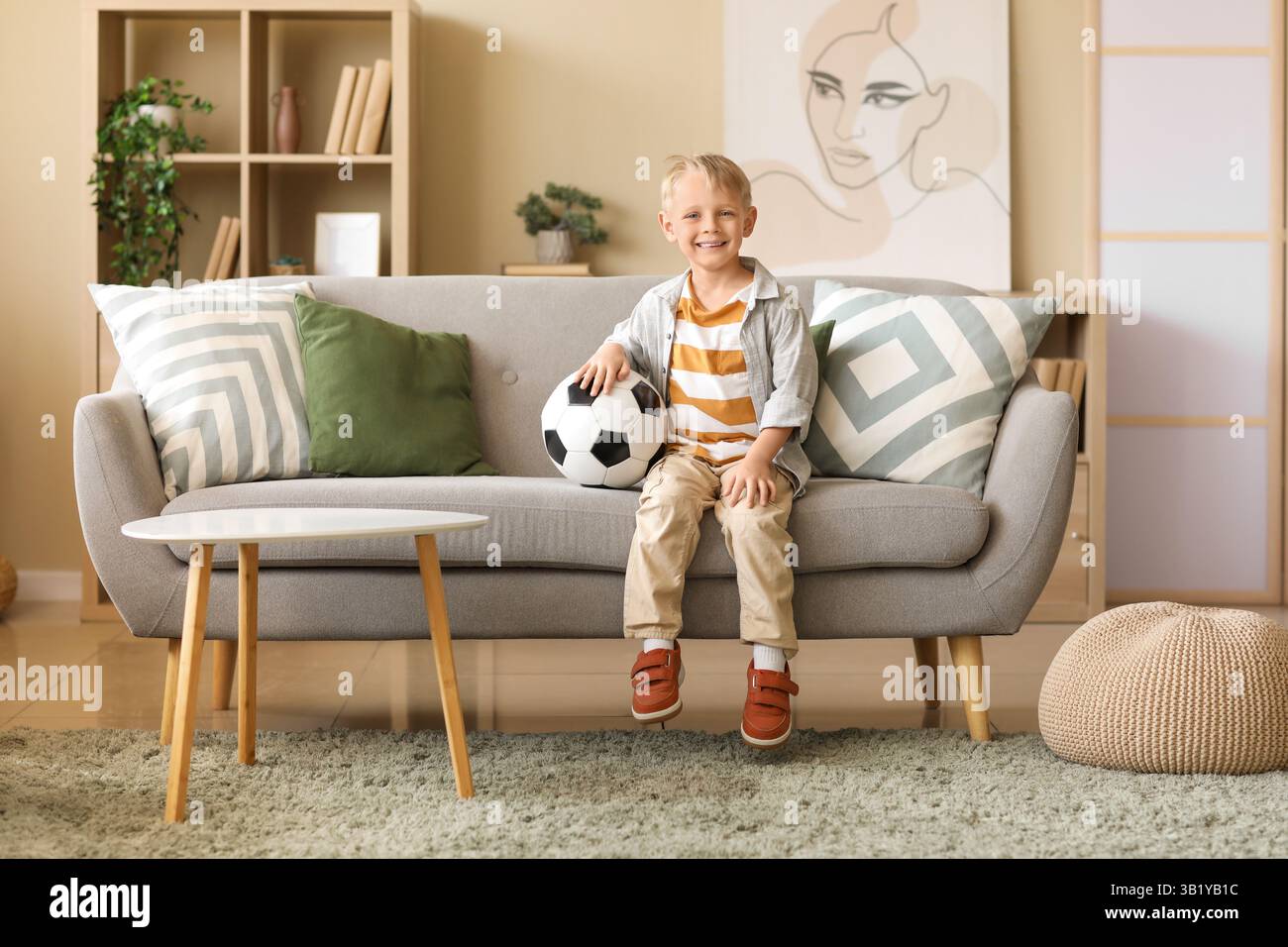 Cute little football player with soccer ball at home Stock Photo - Alamy