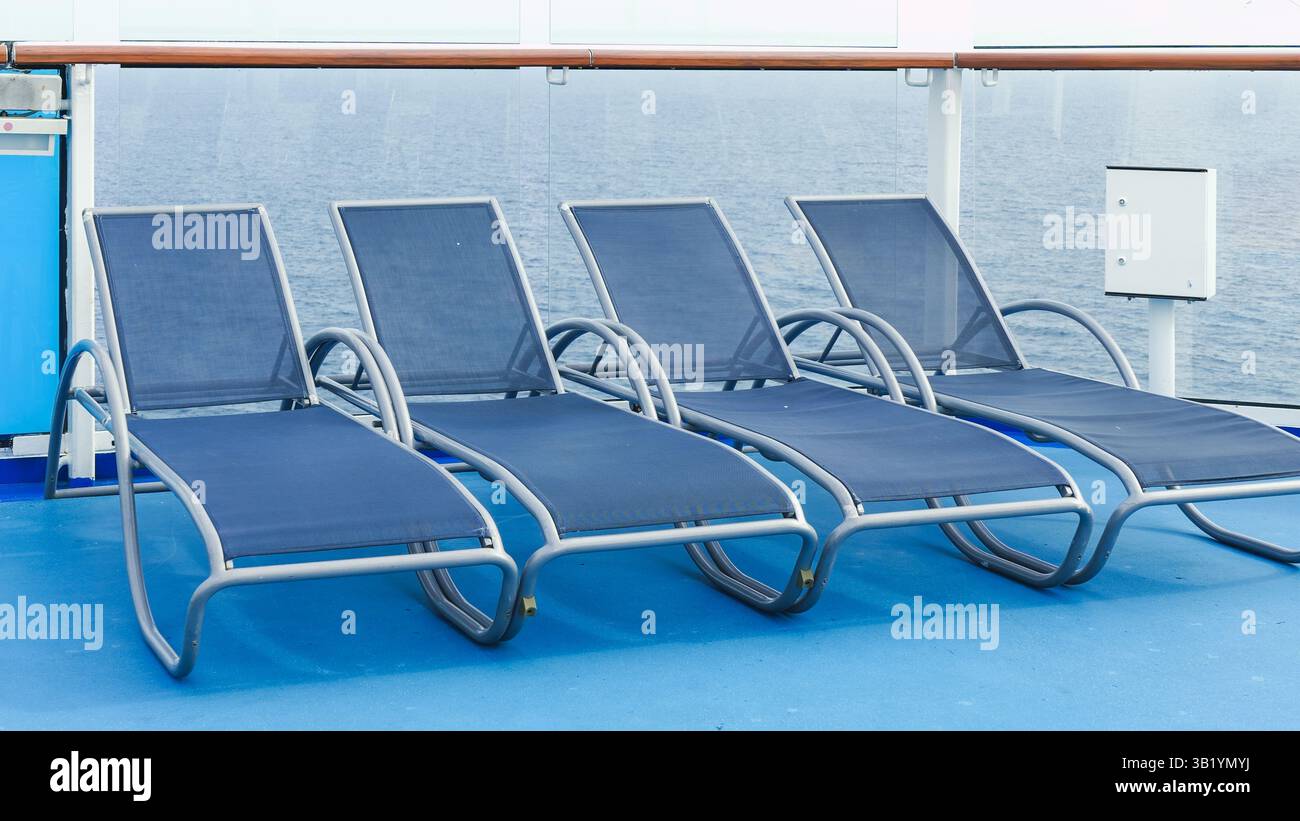A serene view of blue deck chairs perfectly arranged in neat rows on a ...
