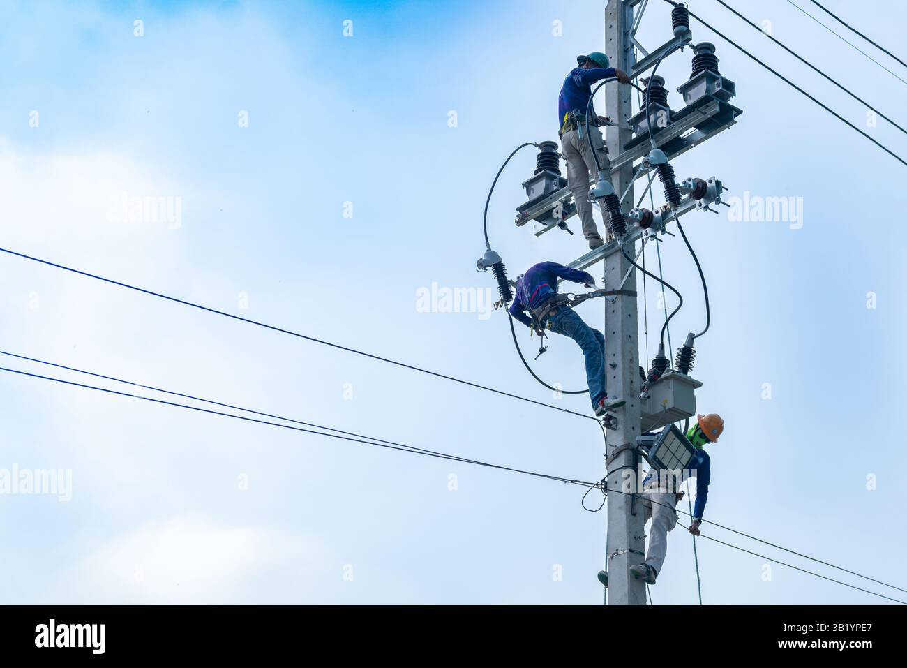 Technician in work clothes and safety helmet are installing high ...