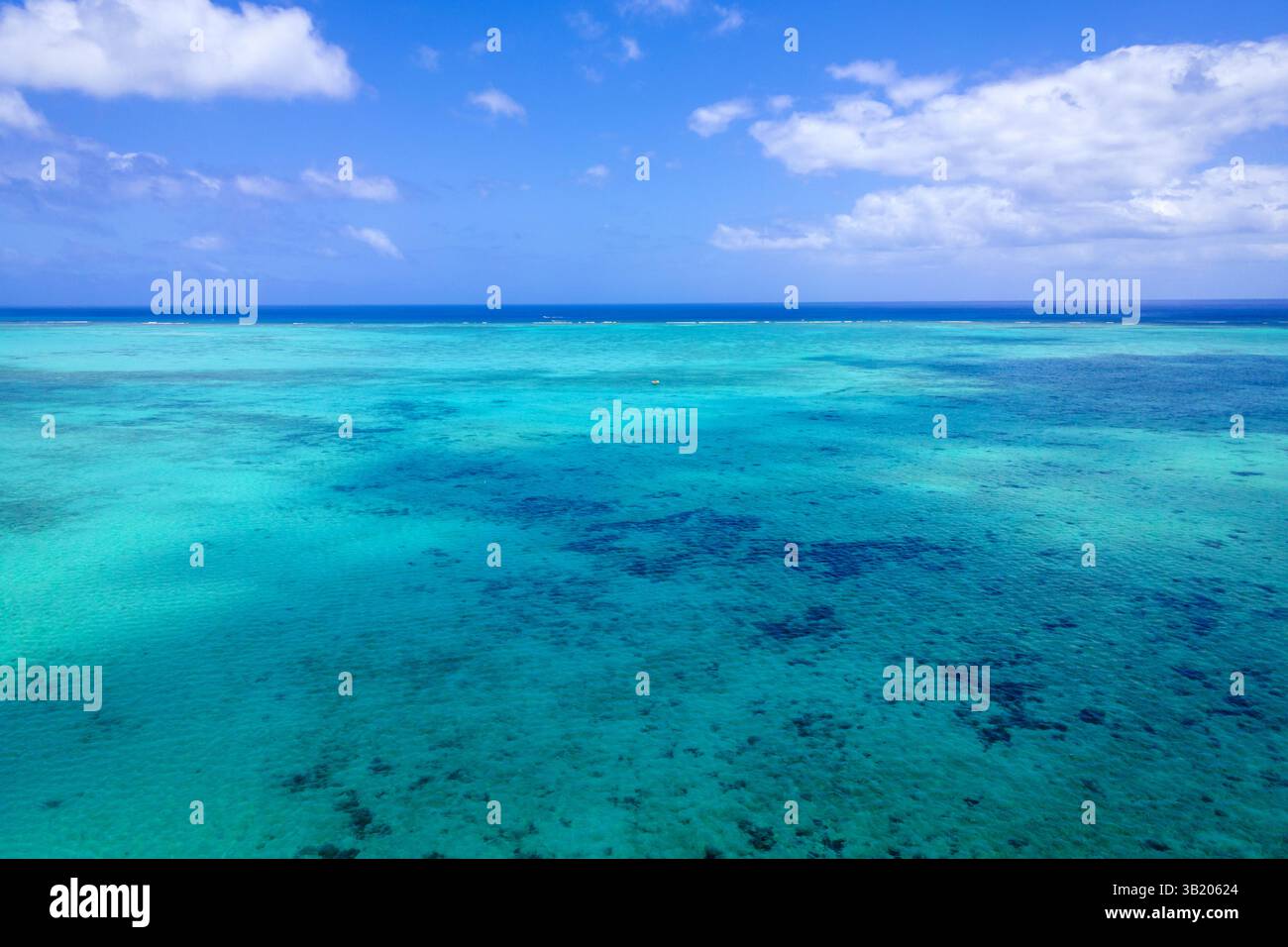 aerial view of turquoise clear tropical water and coral barrel on blue ...