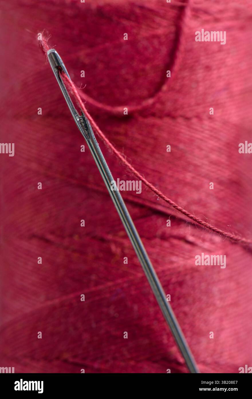 Old Single wooden spool of thread pink color and needle. Simple design ...