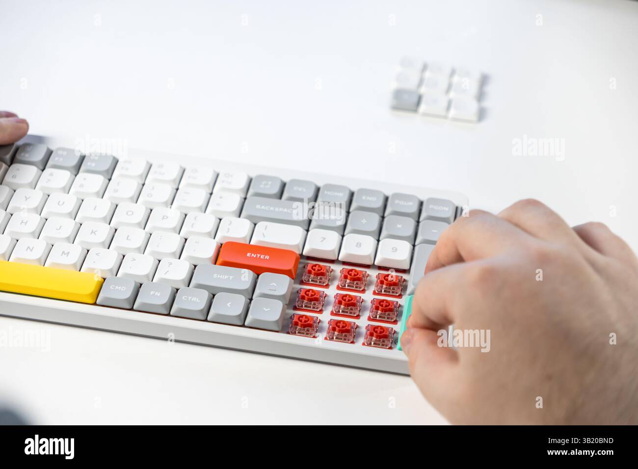 Person's hands interacting with a compact mechanical keyboard showing ...