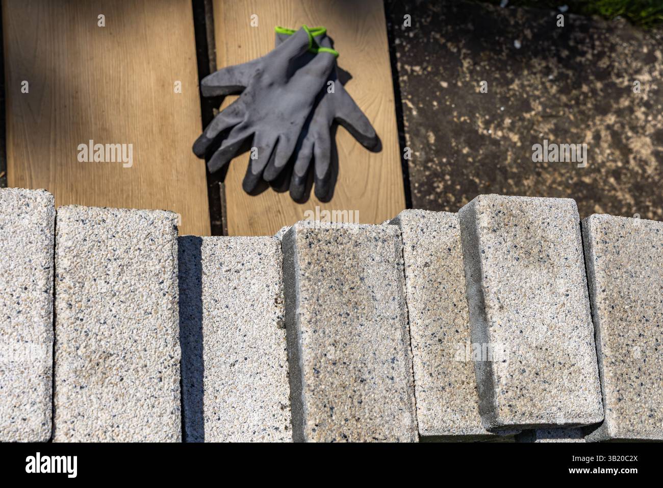 Protective gloves for a bricklayer, placed on a granite block, personal ...