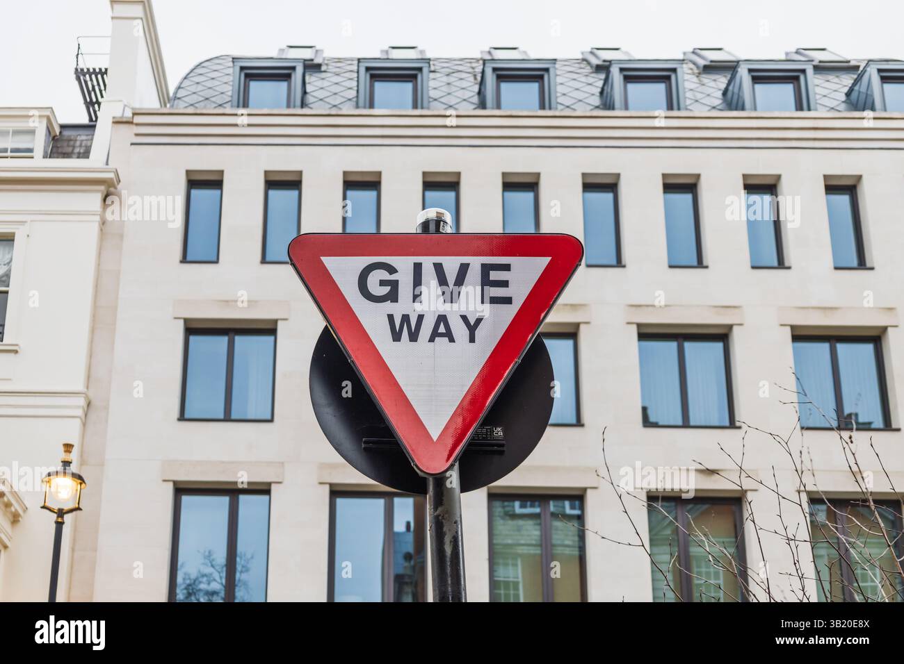 Red Give Way Traffic Sign Mounted on Pole with Modern Building in ...