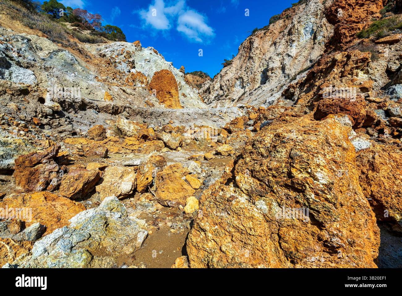 Bright orange, brown, and grey volcanic rocks scattered across rugged ...