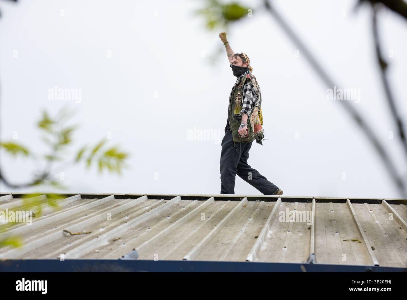 A protester walks with hi fist up on the roof of one of the buildings ...
