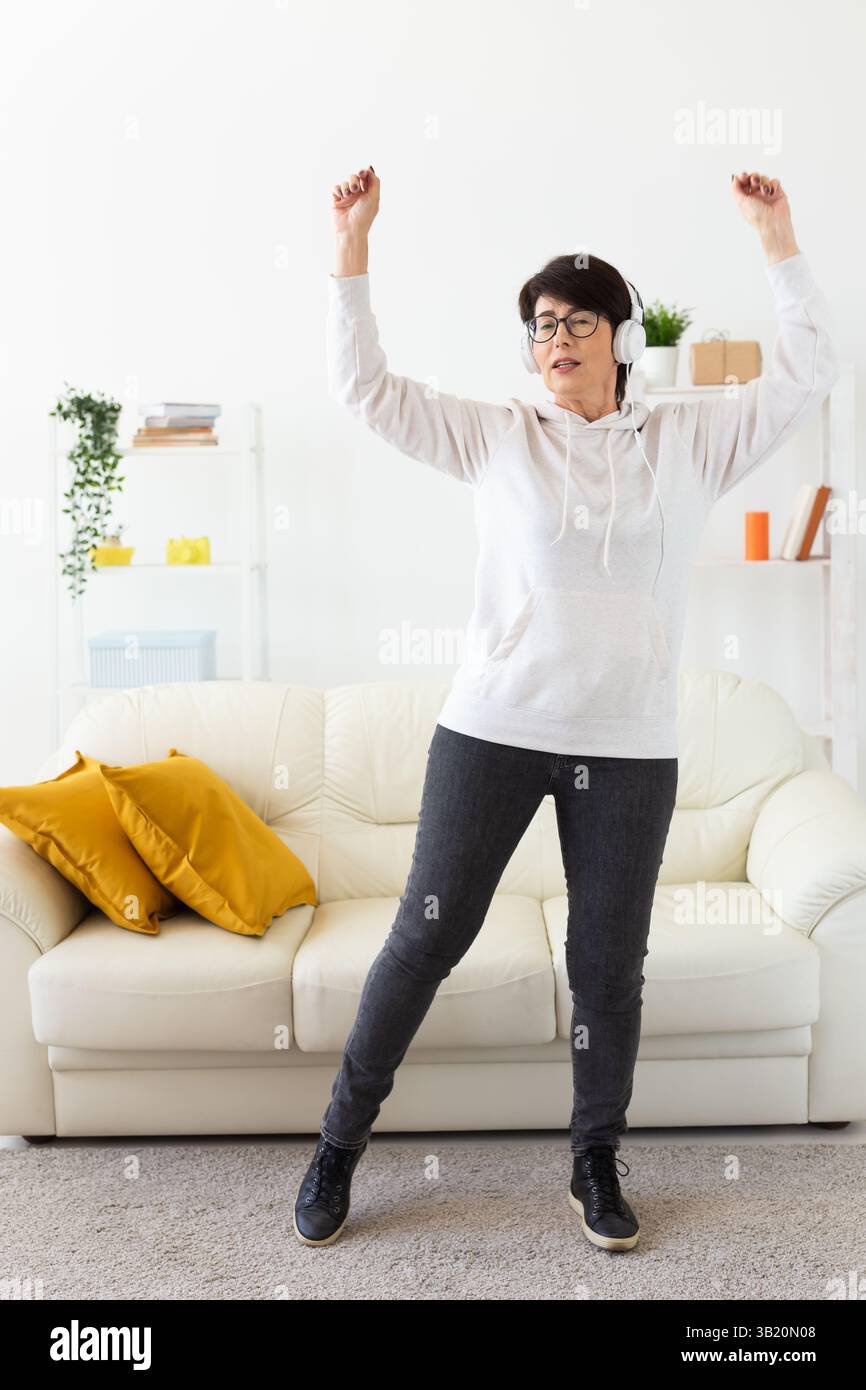 Energetic woman dancing at home while enjoying music. Lifestyle ...