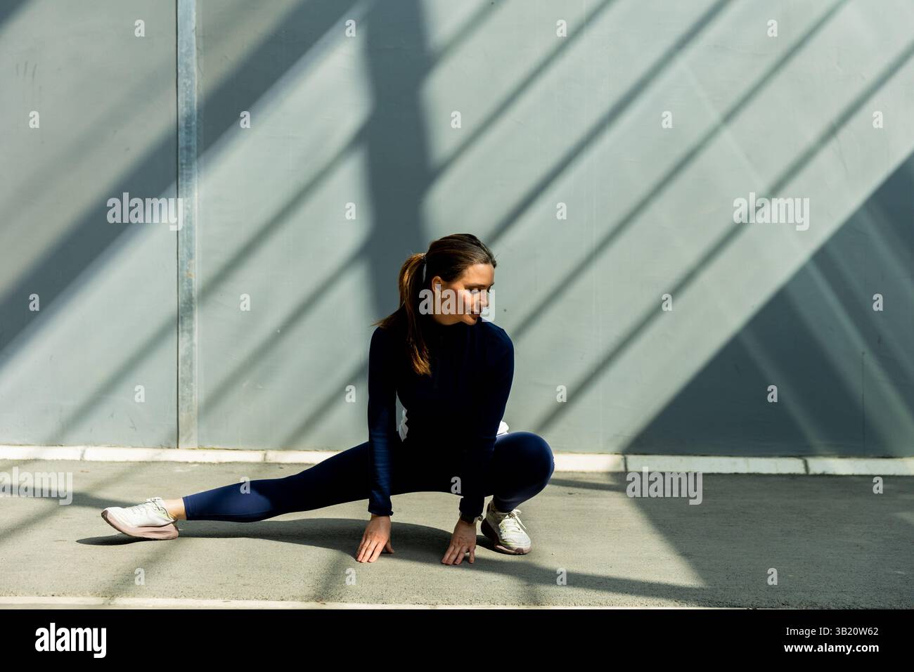 A woman stretches gracefully on the floor, surrounded by striking ...