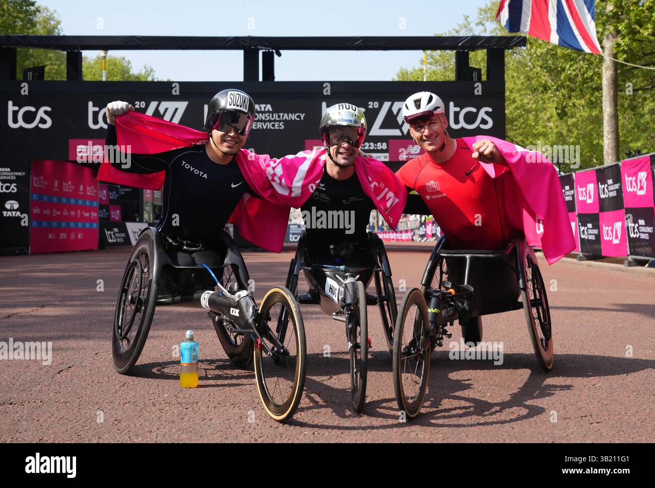 Marcel Hug (centre) celebrates winning the men's wheelchair race ...