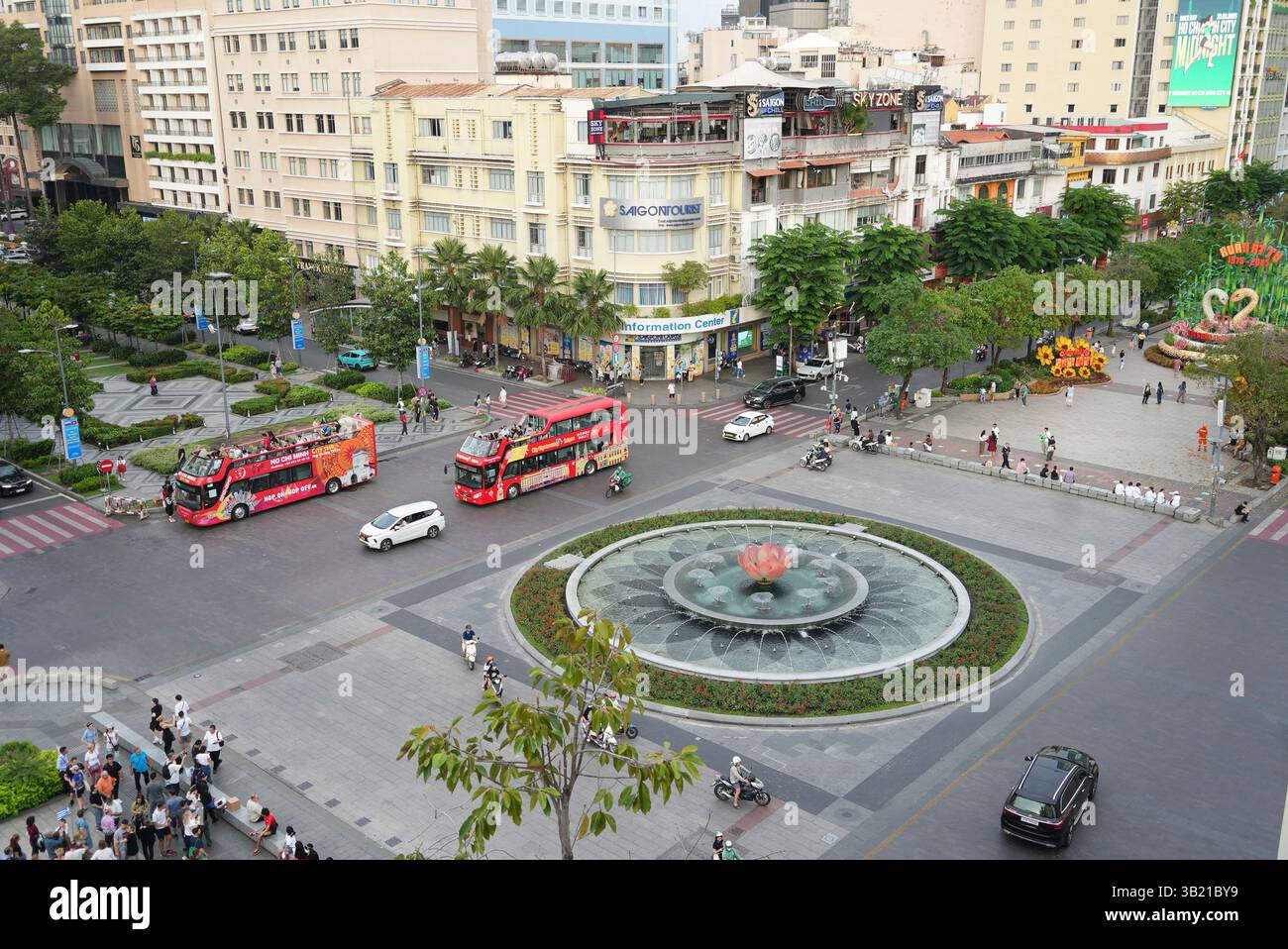 Double-decker tourist buses pass a fountain in Nguyen Hue square in Ho ...