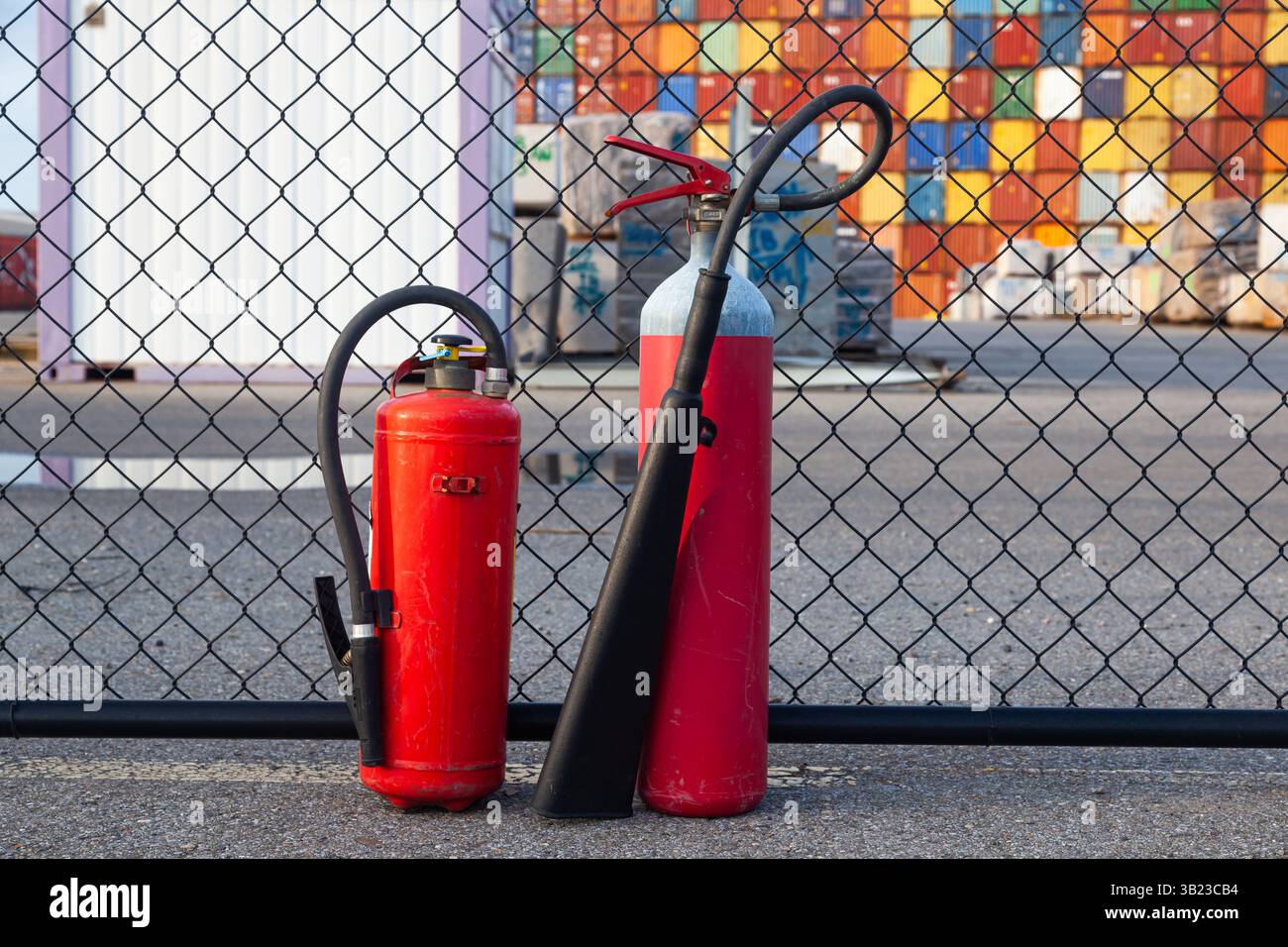 Two hand-held fire extinguishers stand in the closed area of the ...