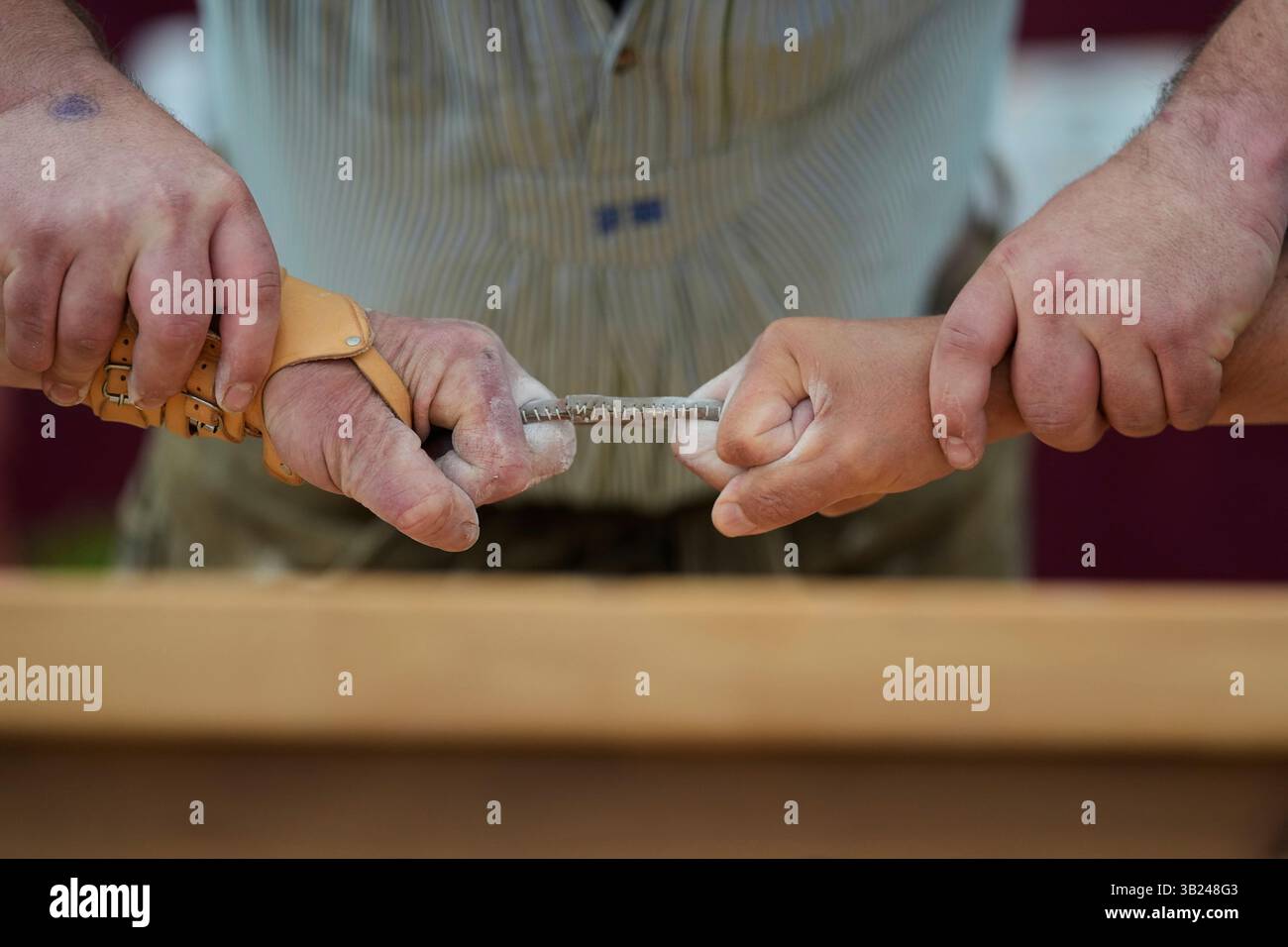 Men dressed in traditional clothes try to pull the opponent over the ...