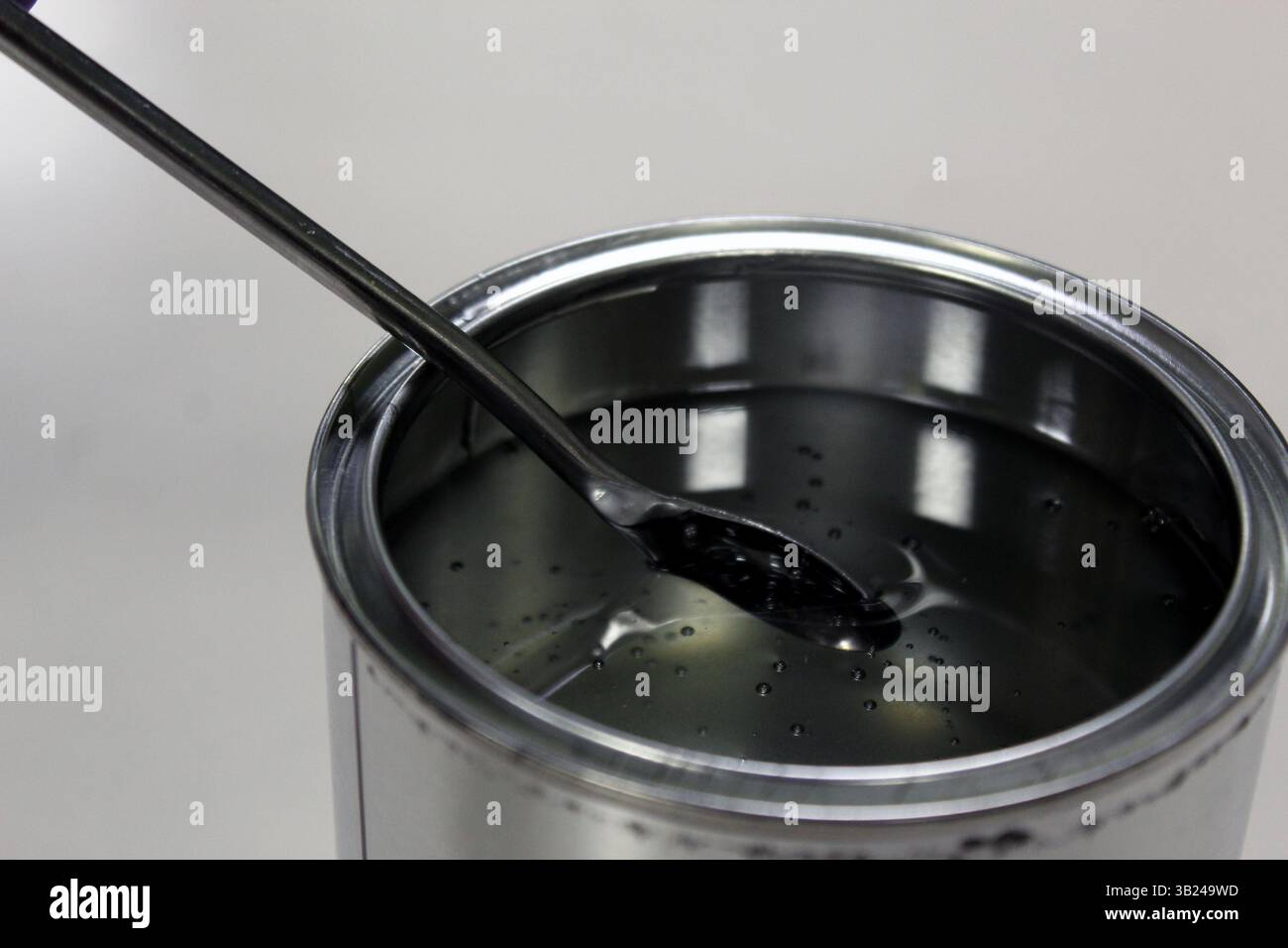 Technician weighing transparent epoxy resin for a paint in a can on a ...