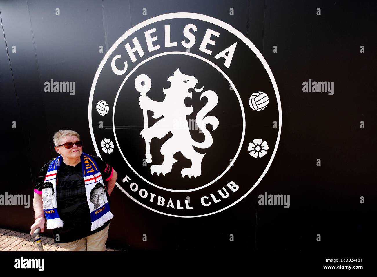 A Chelsea fan poses next to the Chelsea crest near the ground ahead of ...