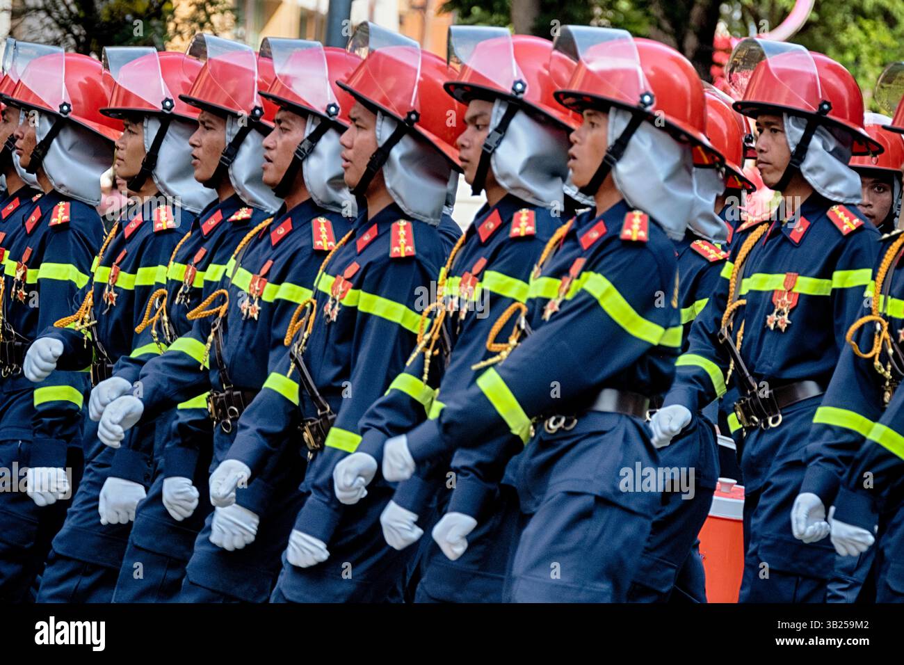 Vietnamese firefighters march along a city street during a dress ...