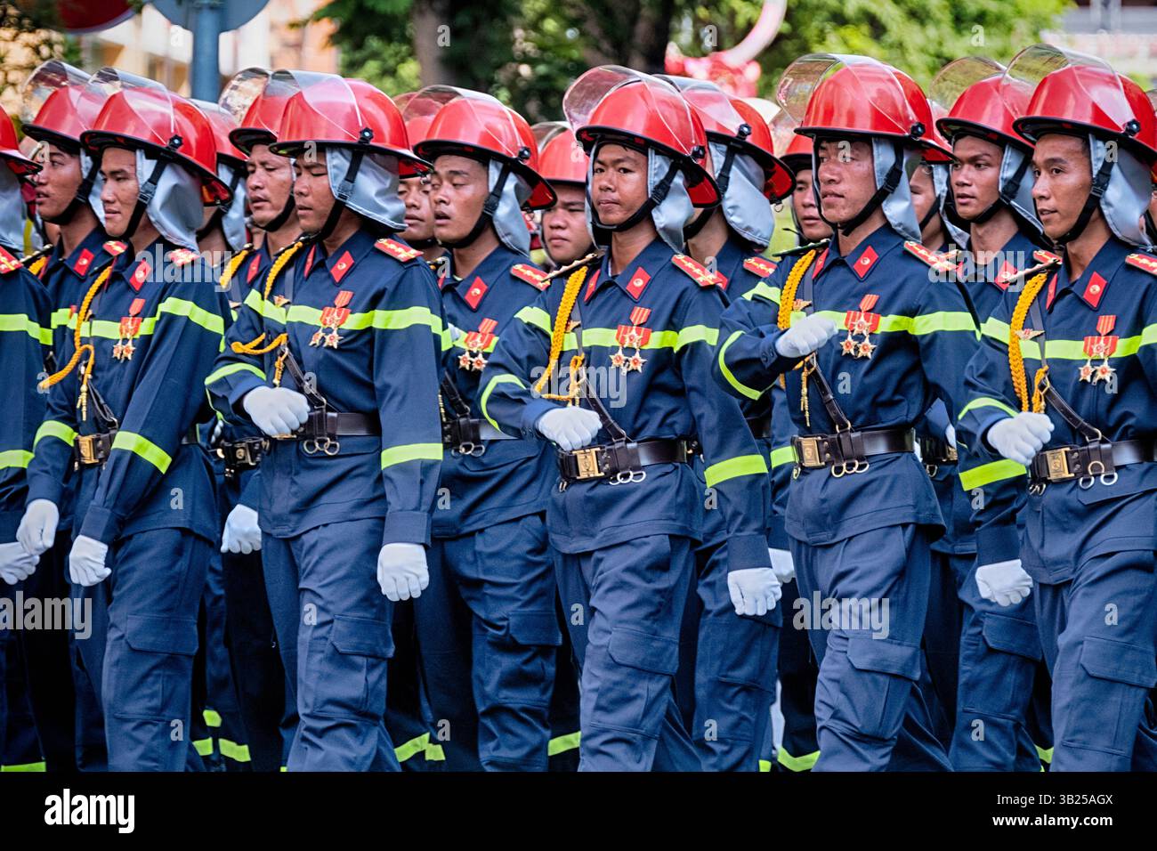 Vietnamese firefighters march along a city street during a dress ...