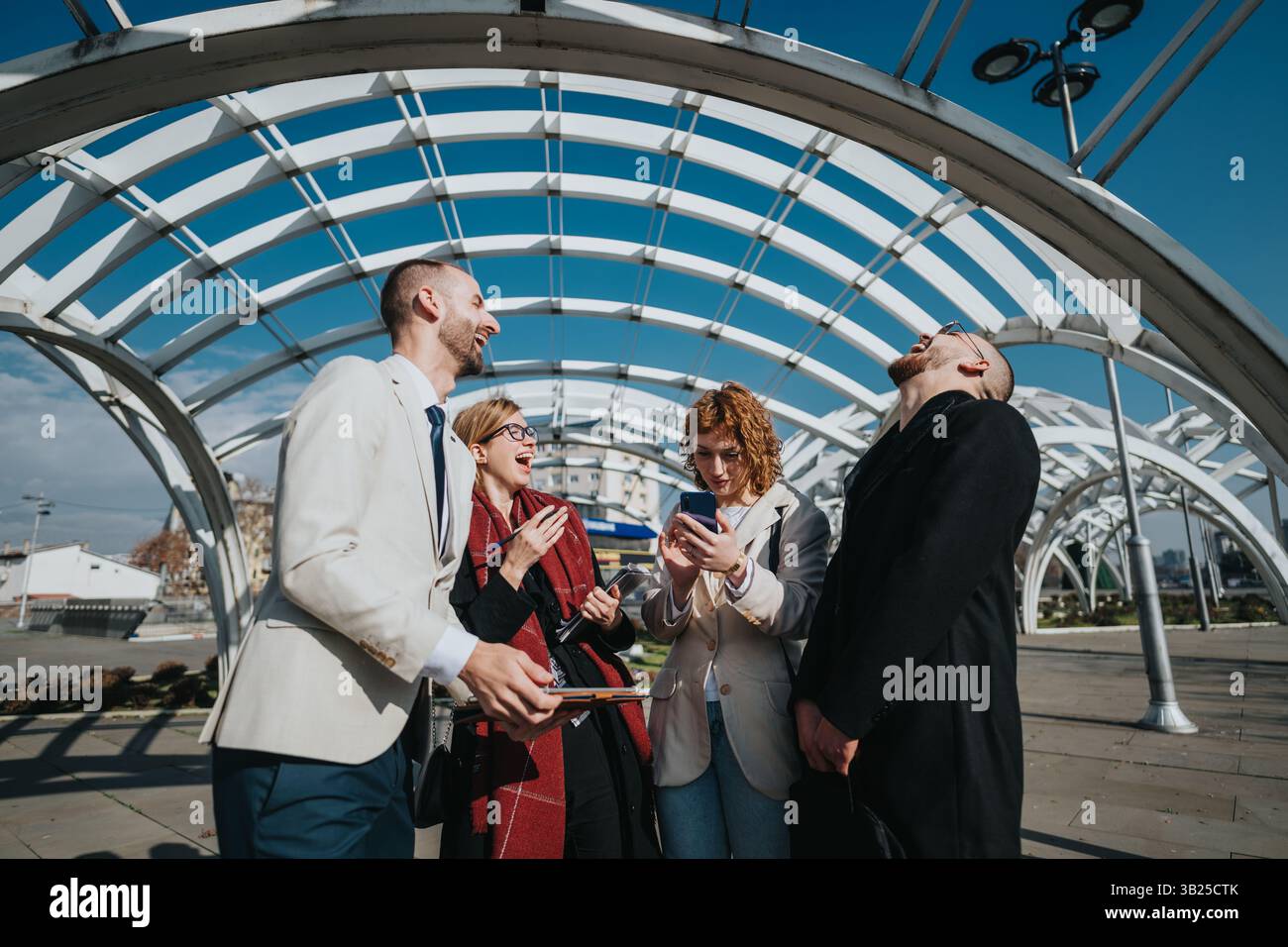 Group of professionals sharing a laugh outside under modern ...