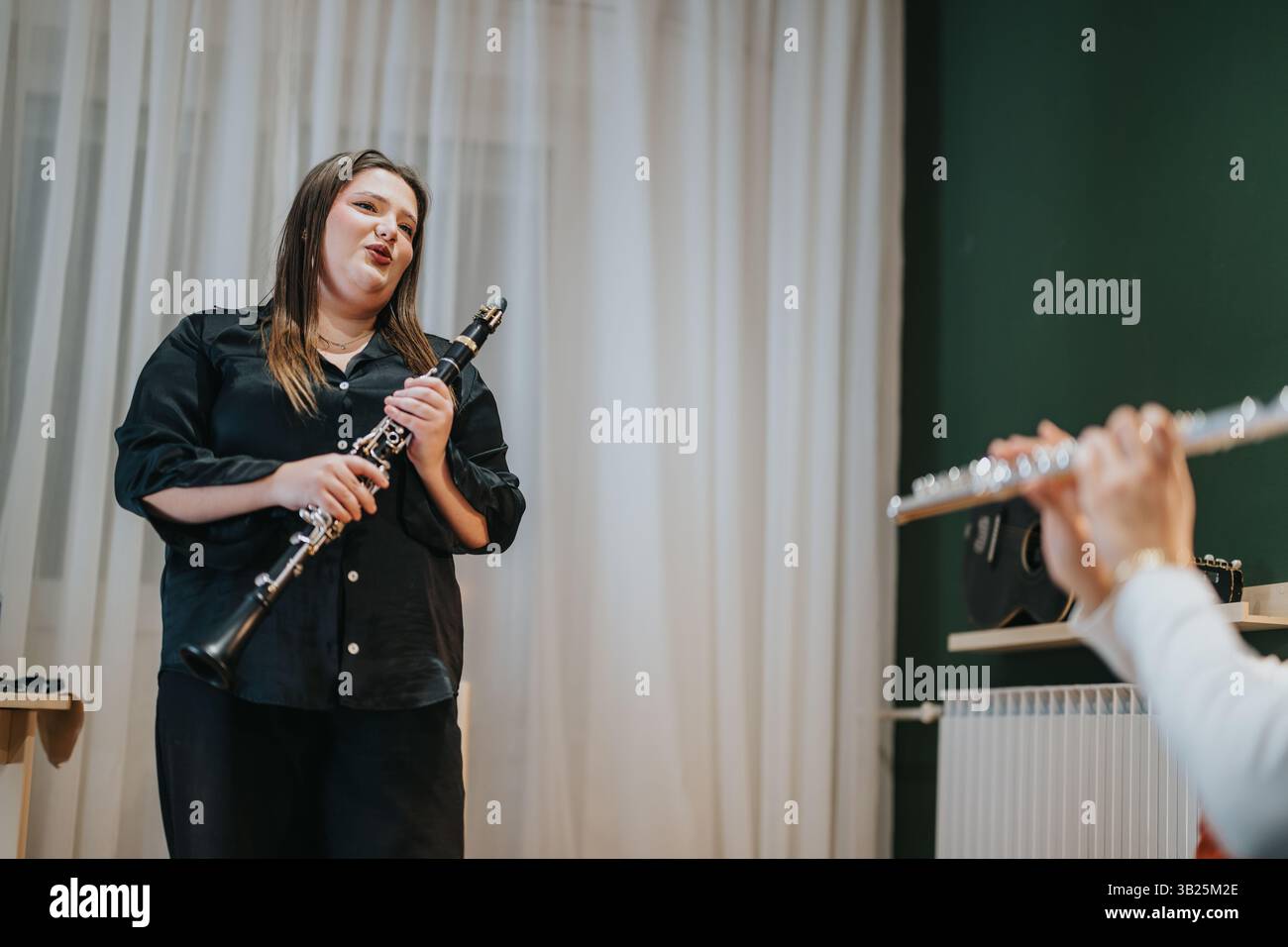 Music teacher leading a clarinet lesson with a student in a classroom ...