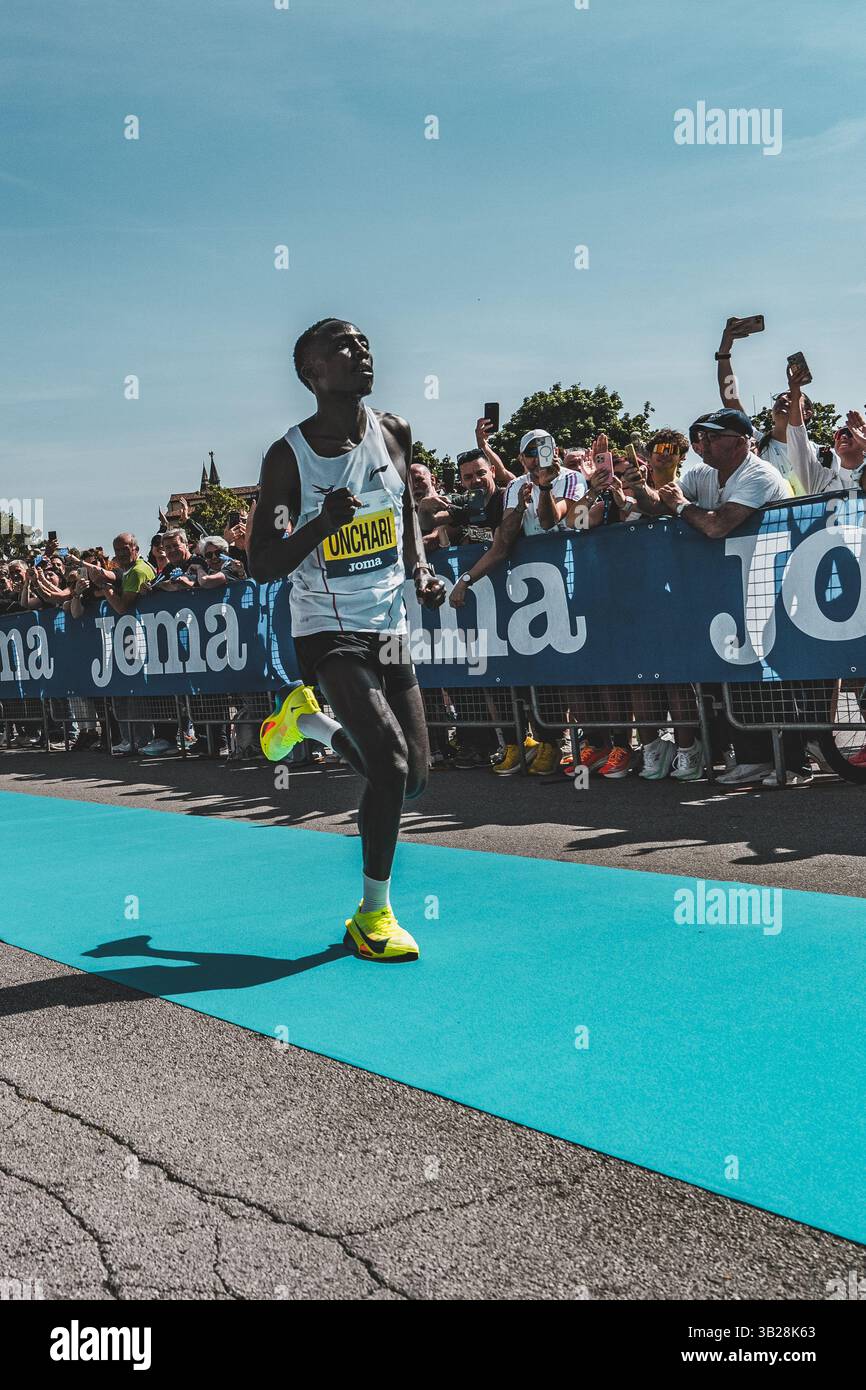 Enock Onchari wins the Padova Marathon 2025, crossing the finish line cheered by spectators ...