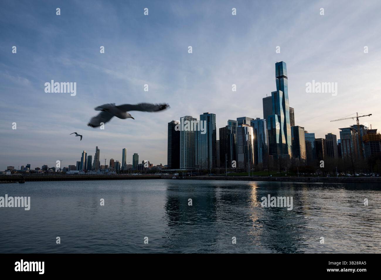 The sun is seen setting behind the skyline of the Streeterville ...