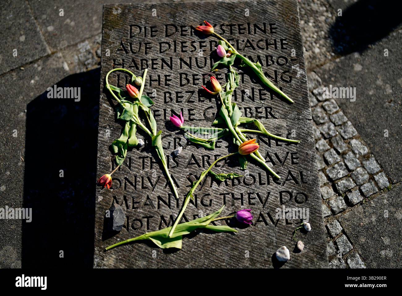 Flowers on a memorial stone during a service at Bergen-Belsen, to mark ...