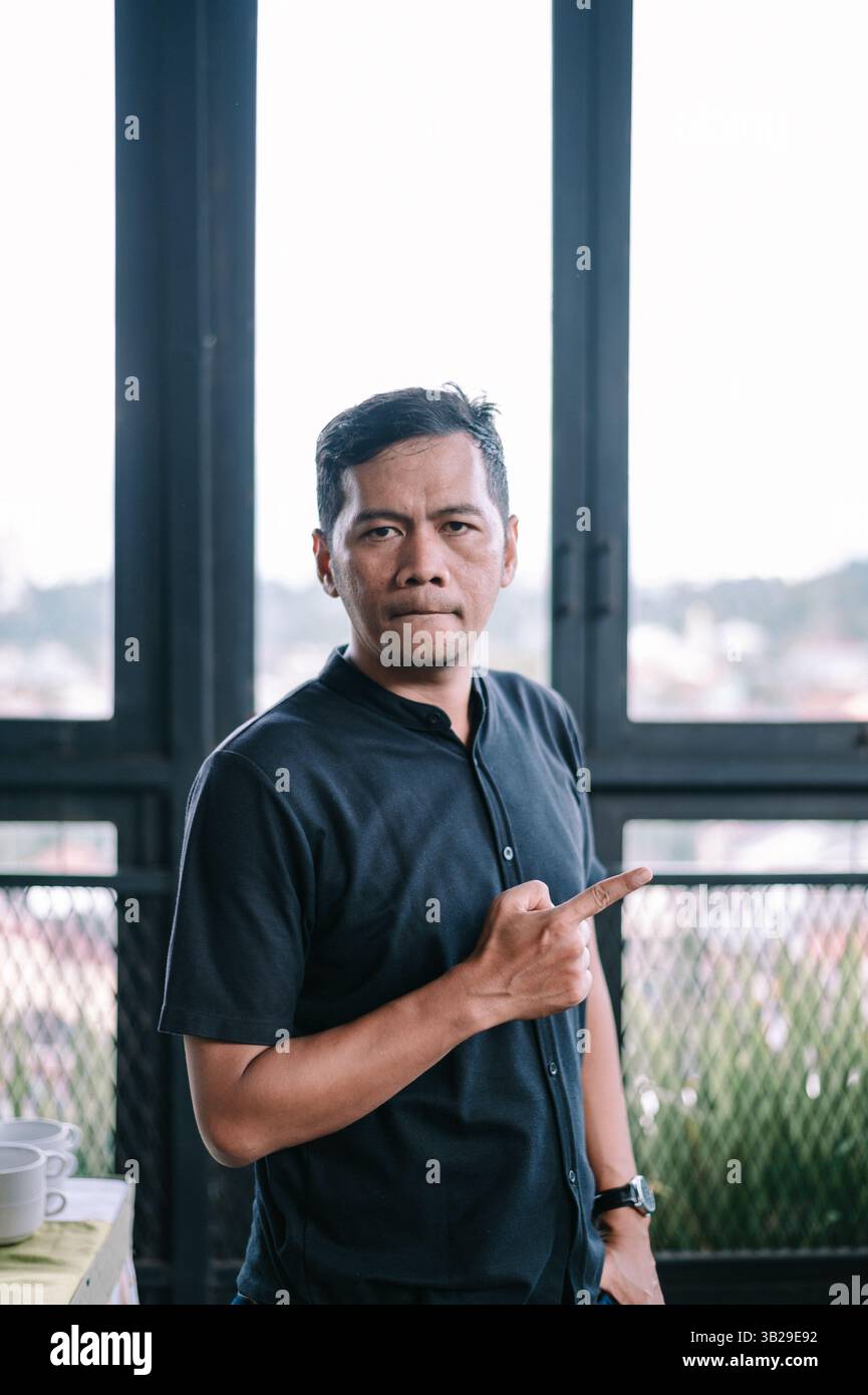 Confident man pointing his finger. Serious expression portrait against ...