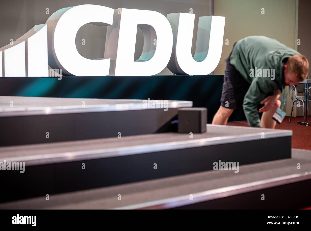 Berlin, Germany. 27th Apr, 2025. A worker prepares the hall for the CDU ...