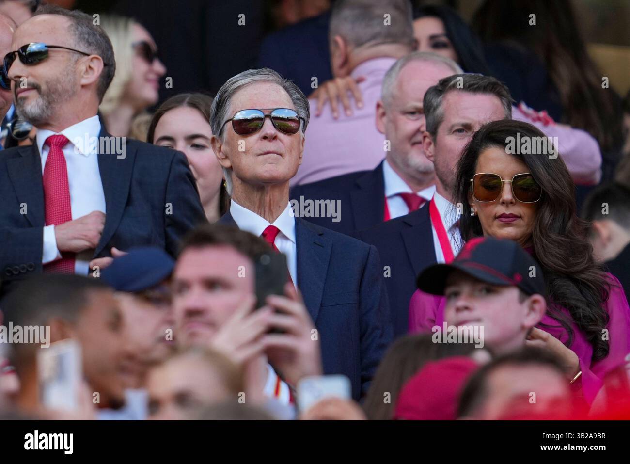 Liverpool owner John Henry, center, and his wife Linda Pizzuti take their seats before the ...