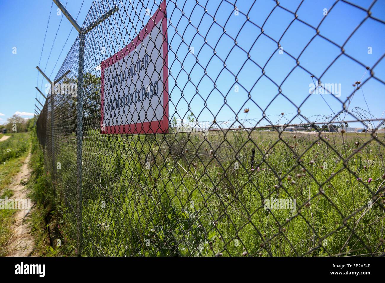 Translation: "Military zone, no entry." Barbed wire fence preventing ...