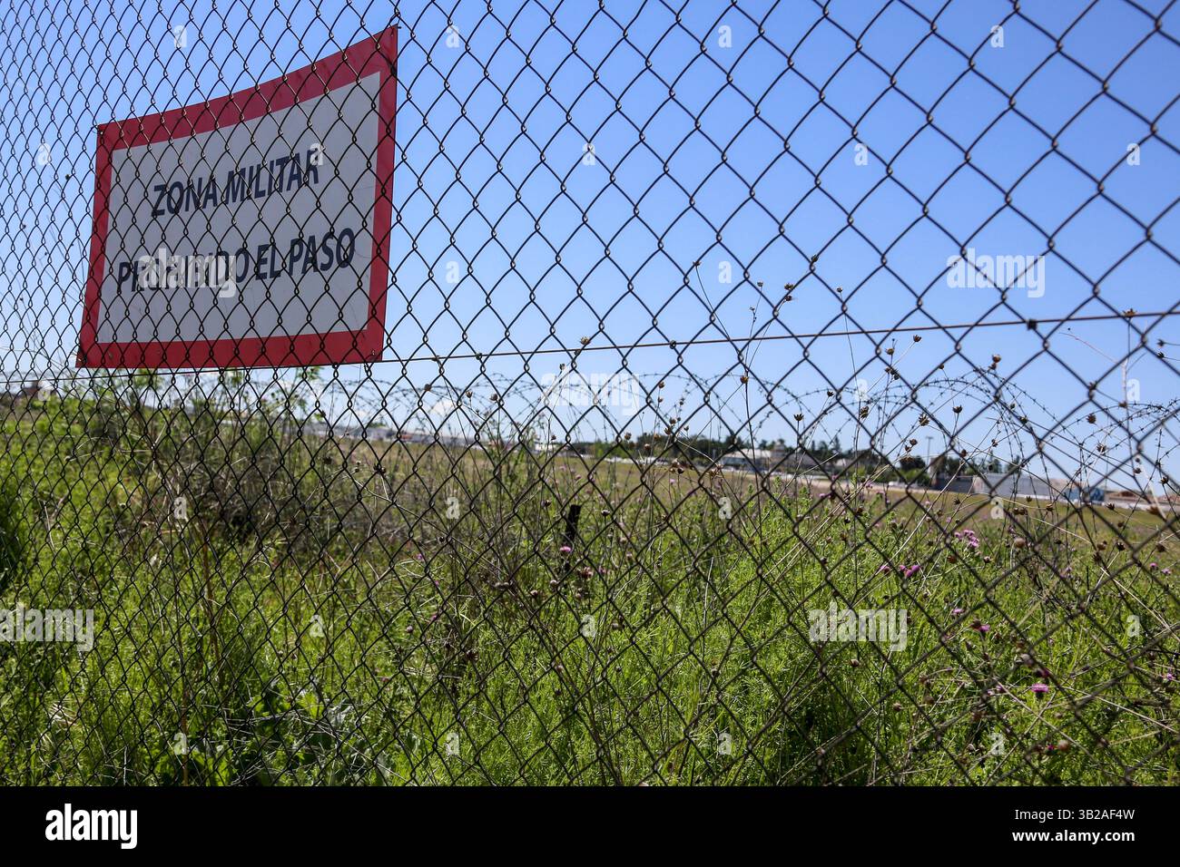 Translation: "Military zone, no entry." Barbed wire fence preventing ...